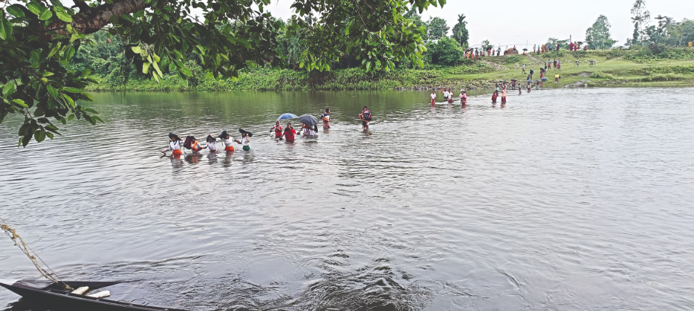 Students risk lives to cross swollen Raidak River in absence of bridge
